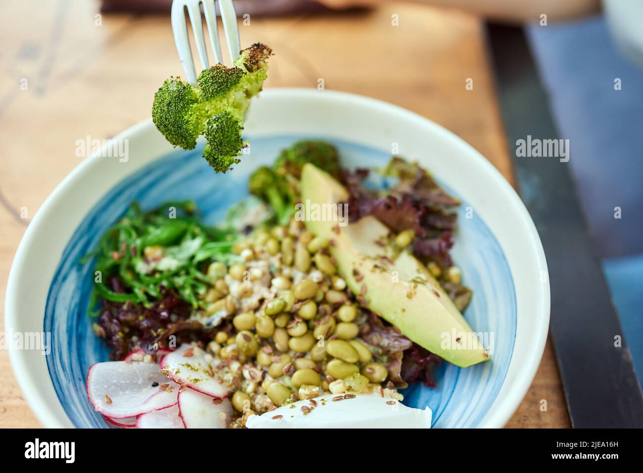 Woman eating quinoa broccoli salad. Eat healthy food lifestyle concept ...