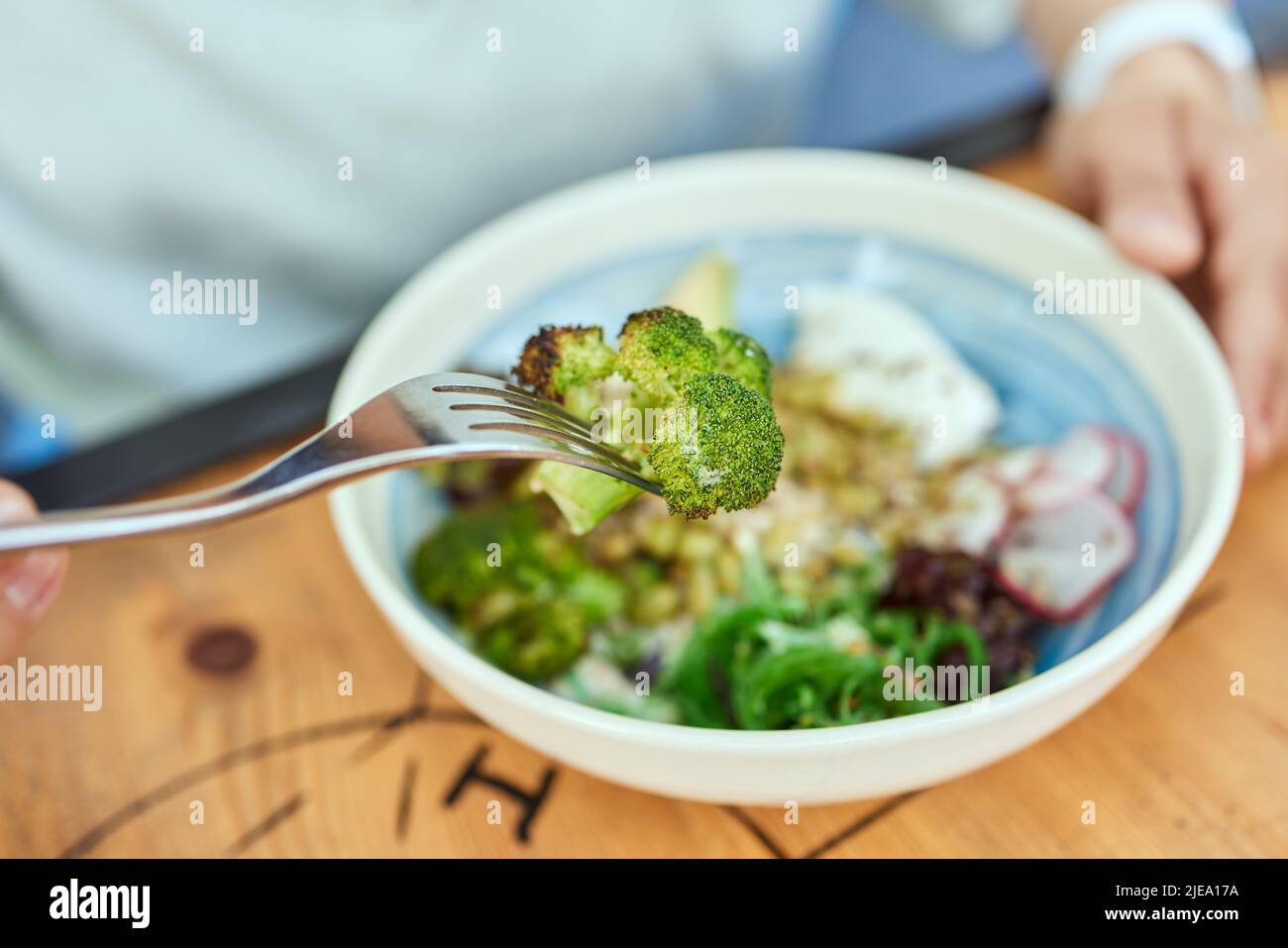 Woman eating quinoa broccoli salad. Eat healthy food lifestyle concept ...
