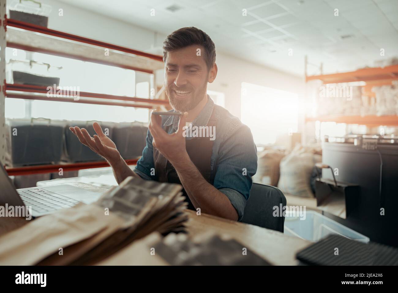 Male barista record audio message on phone working on small coffee ...