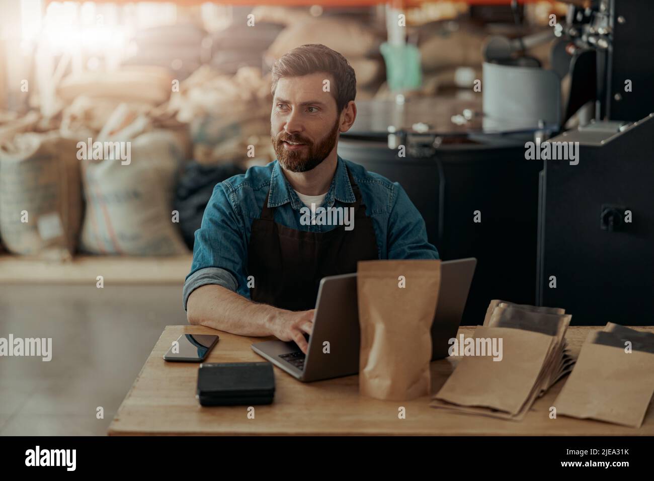 Business owner of small coffee factory working laptop on background of ...