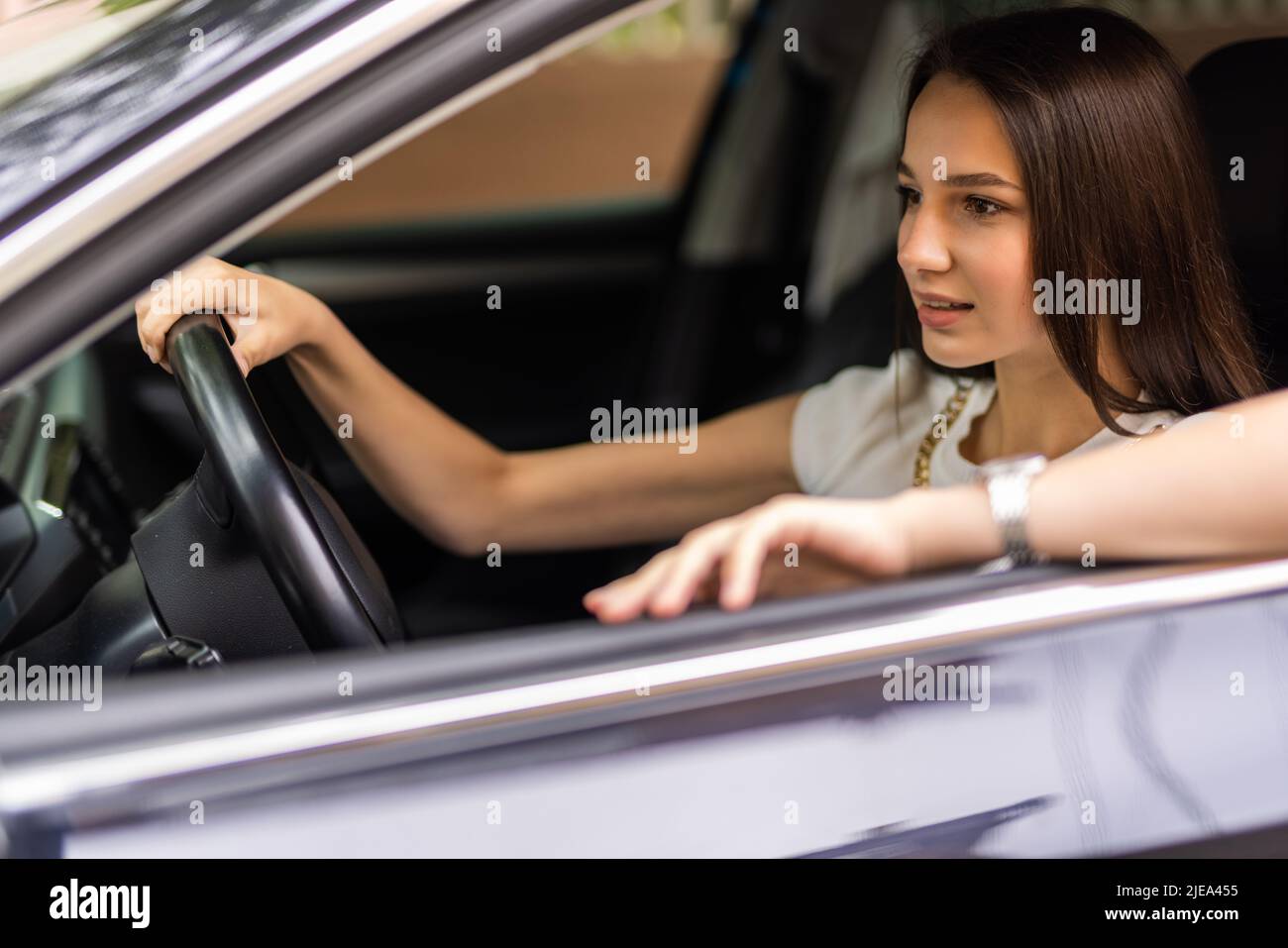 Beautiful young happy smiling woman driving her car Stock Photo - Alamy