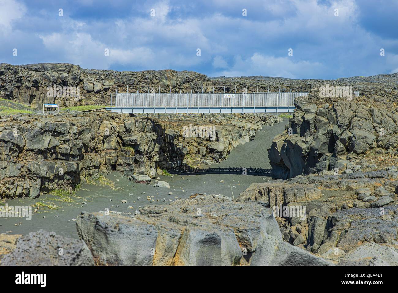 Lava rocks with a metal bridge on Reykjanes Peninsula. Transition of ...