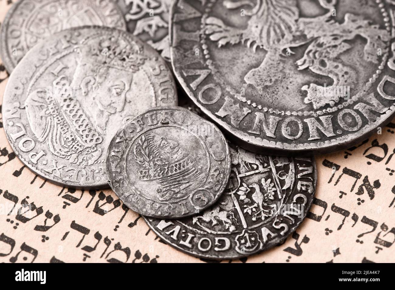 Pile of old silver coins on open Siddur page. Selective focus. Closeup ...