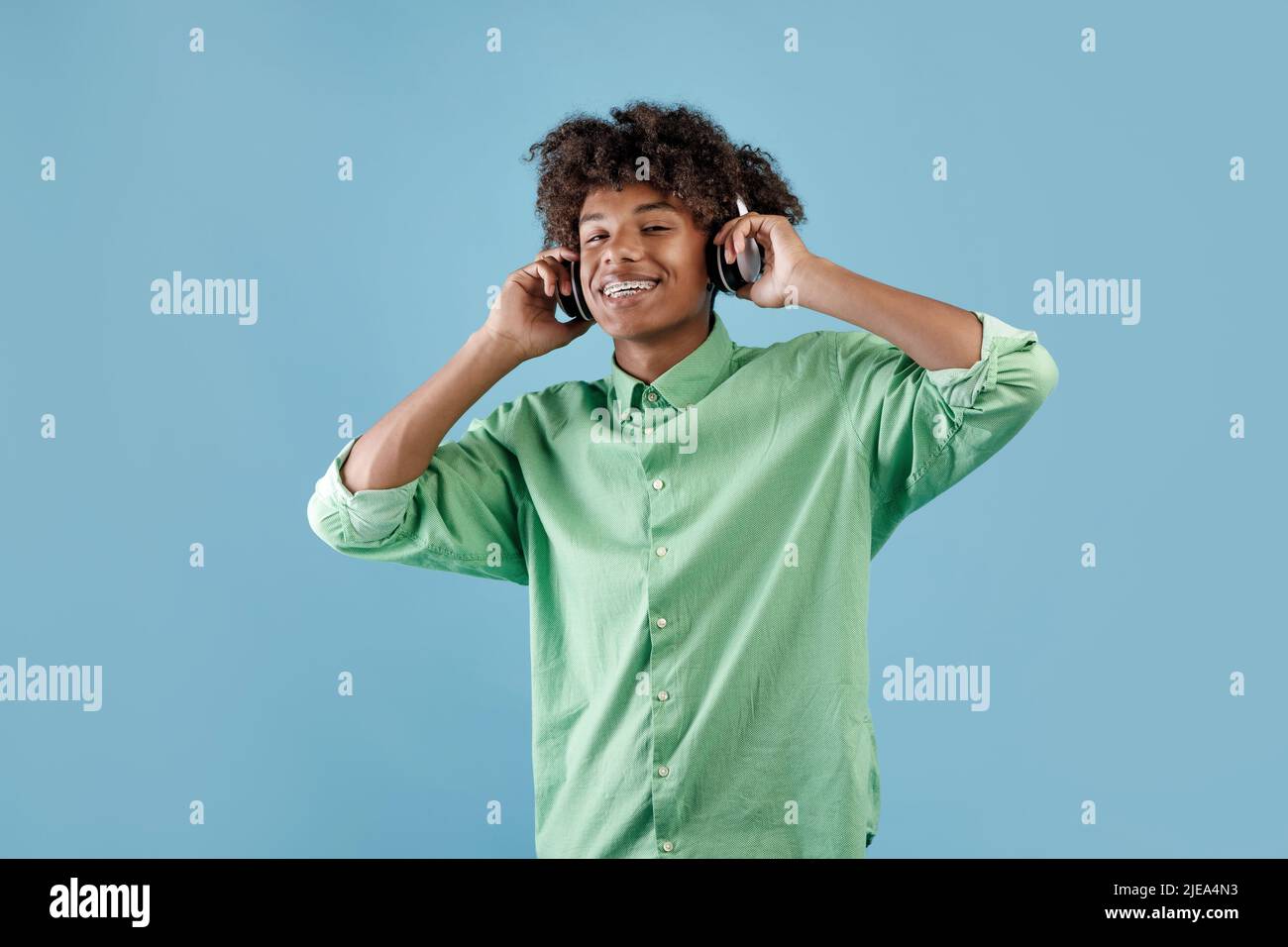 Happy peaceful african american guy listening to music in wireless ...