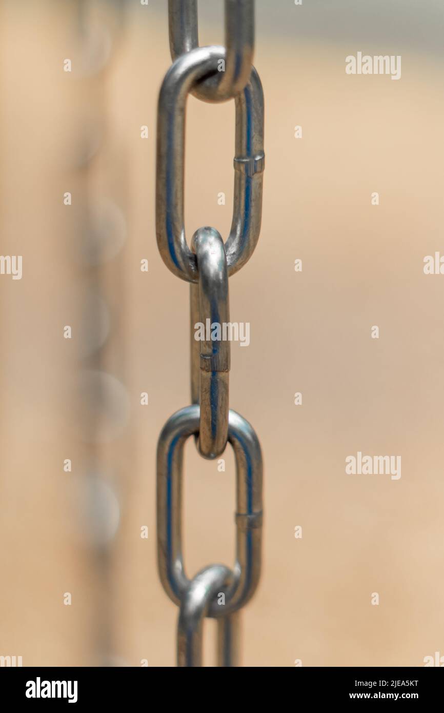 Vertical, partial blurred iron chain on blurred background. Low angle ...