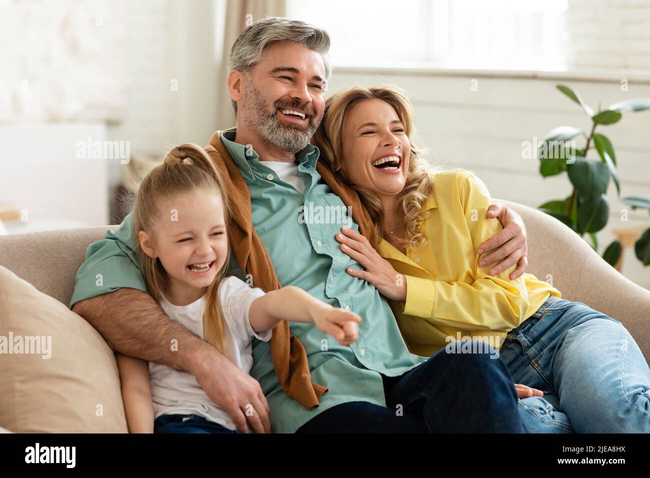 Middle Aged Parents Hugging Little Daughter Laughing Bonding At Home Stock Photo - Alamy