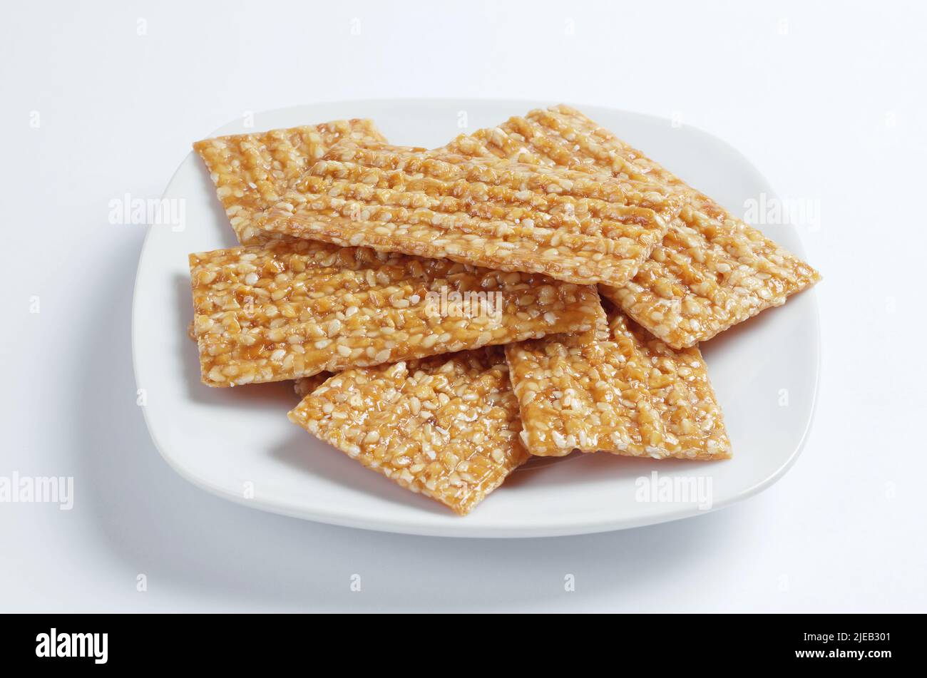 Honey Sesame Bars in plate on a white background close up Stock Photo ...