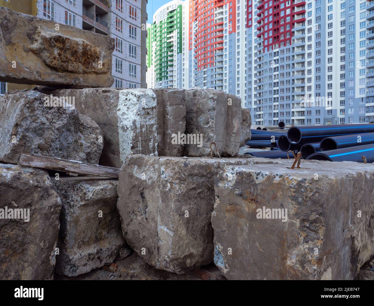 A building site with huge concrete blocks and big black pipes in the ...