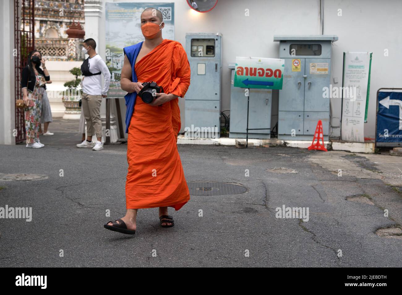 Buddhist monk with a face mask and camera in the street Stock Photo - Alamy
