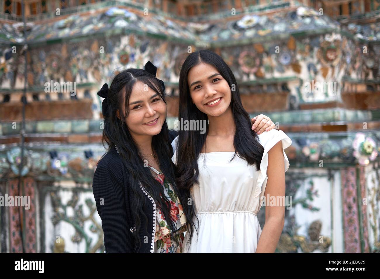 Portrait of two asian friends looking at camera in a temple in Thailand ...