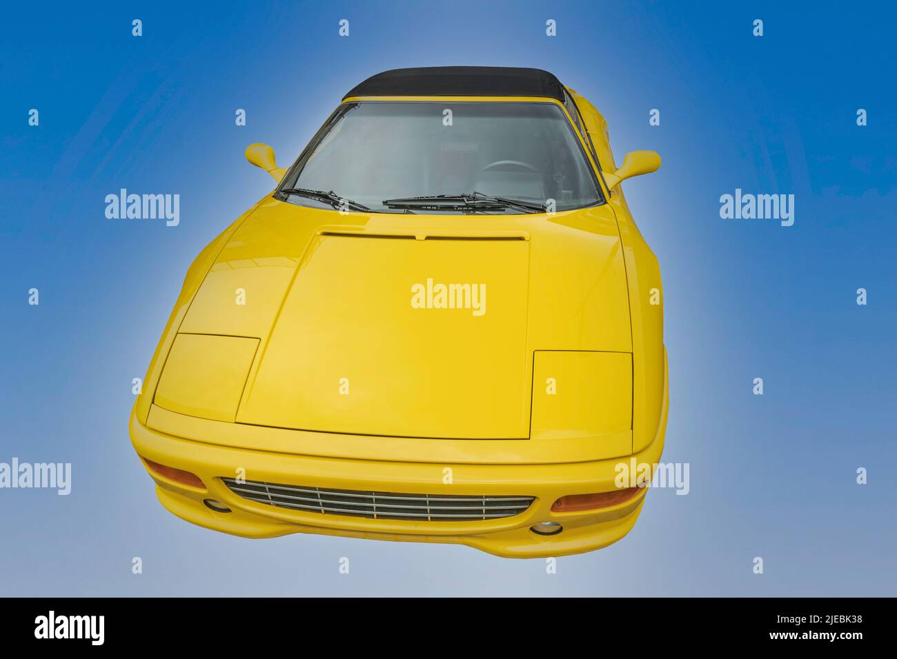 Yellow convertible Ferrari sports car against the blue sky with clouds ...