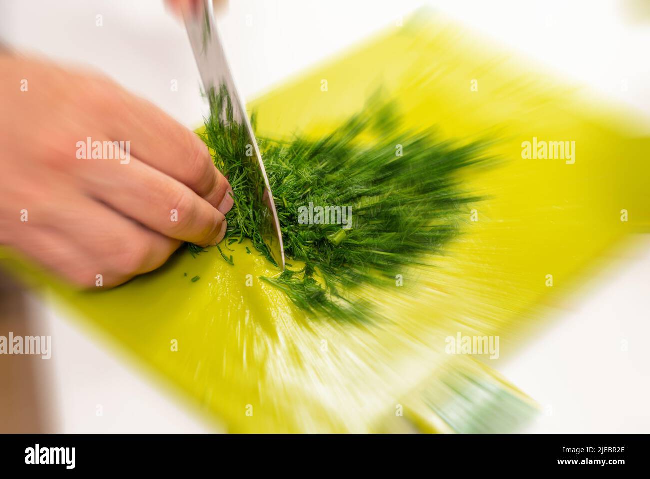top view of man cutting dill for making salad with kitchen knife ...