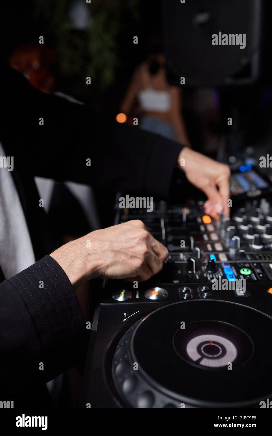 Hands of male Dj playing music on modern midi controller turntable ...