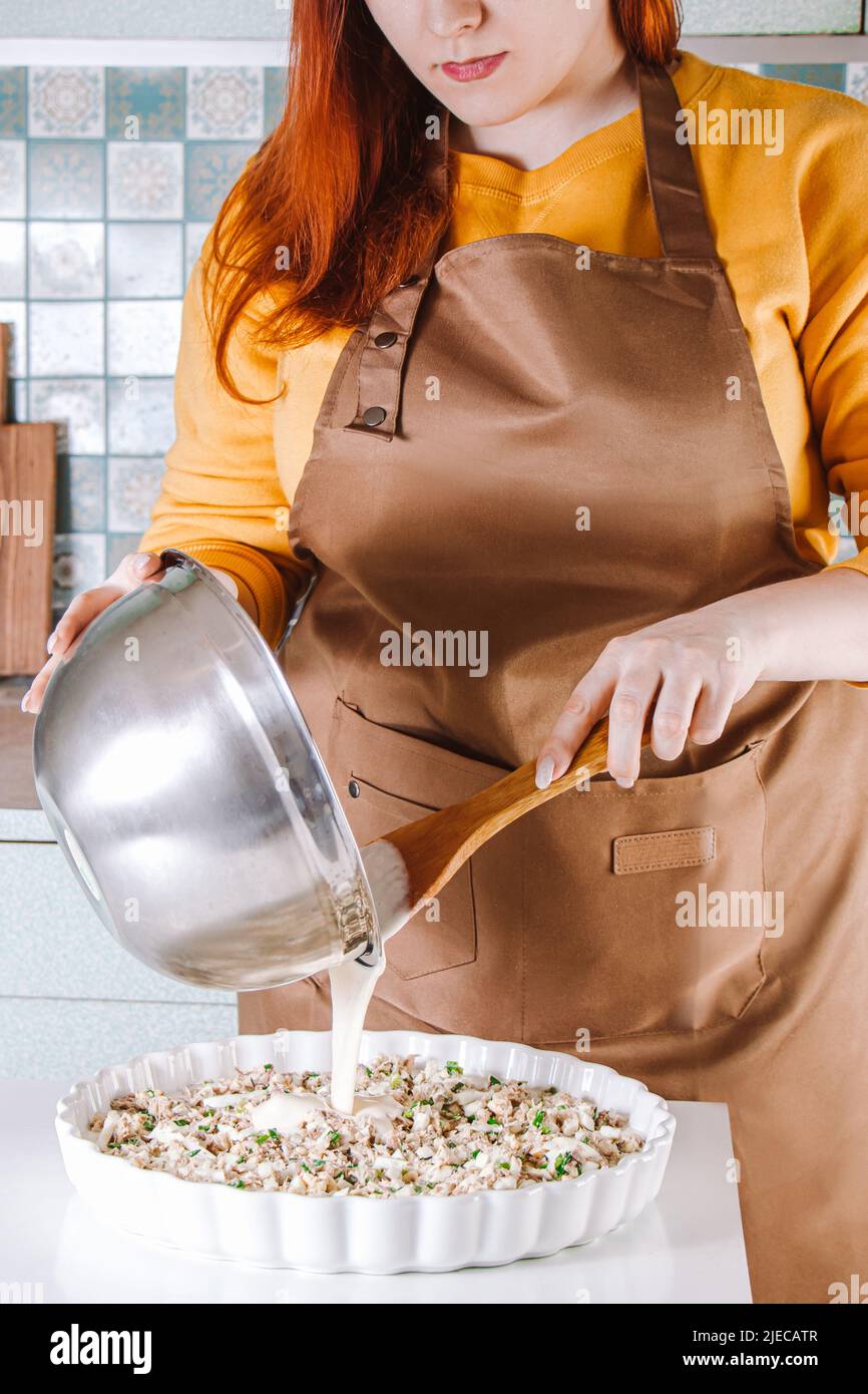Young woman cooking food in home kitchen. Process of making homemade ...