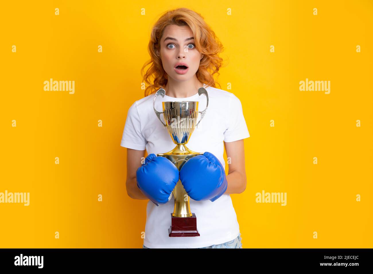 Woman in boxing gloves hold champion winner cup trophy. Funny girl in ...