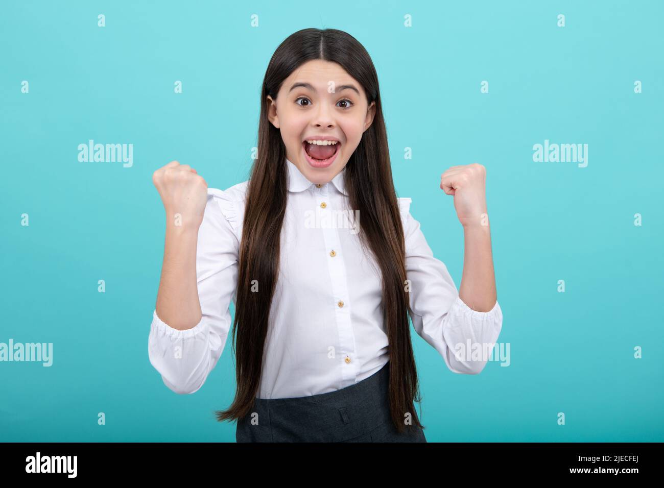 Studio portrait of teenager child doing winner gesture. Kid rejoicing ...