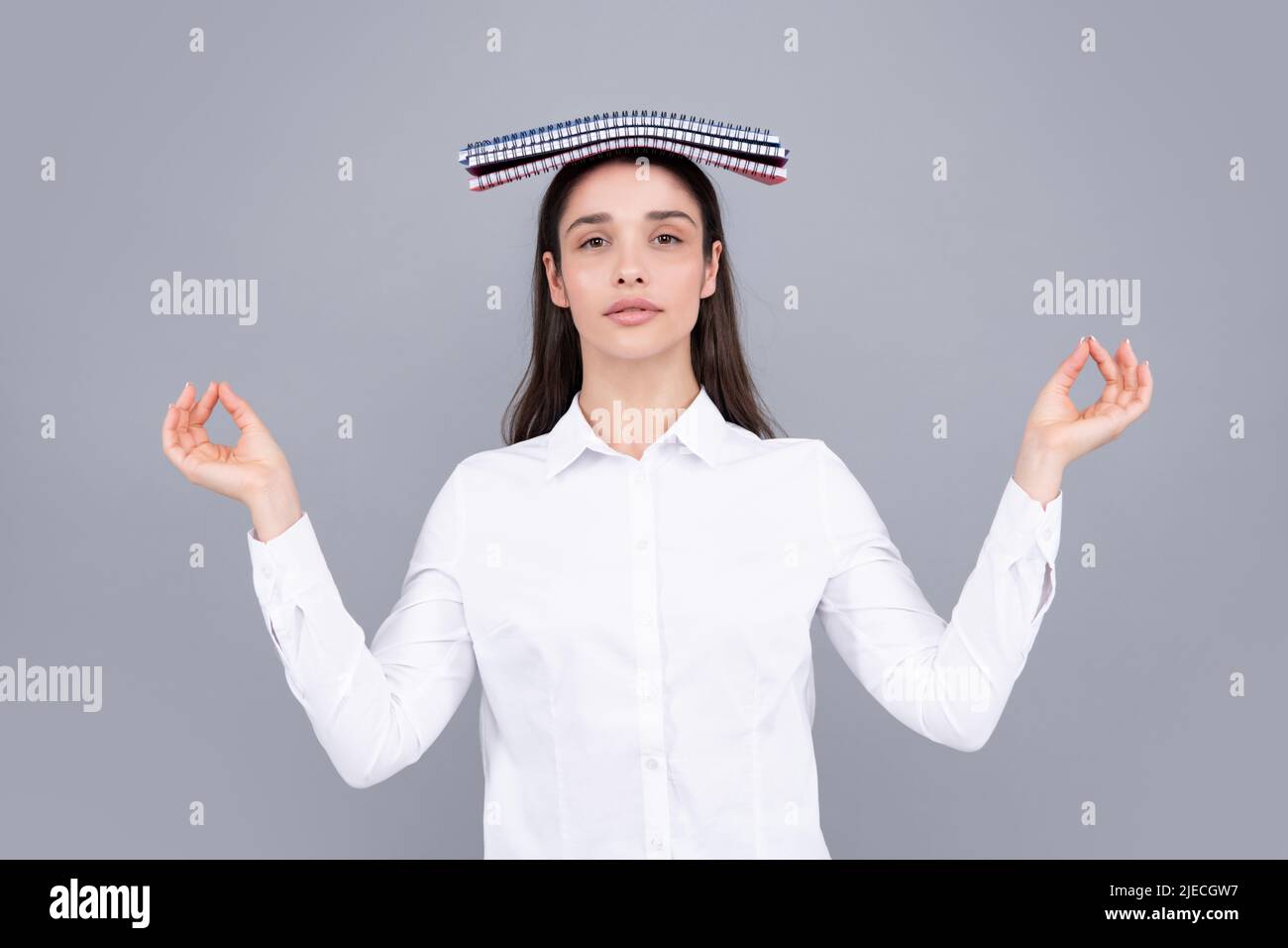 Female student holds books isolated on gray background in studio ...
