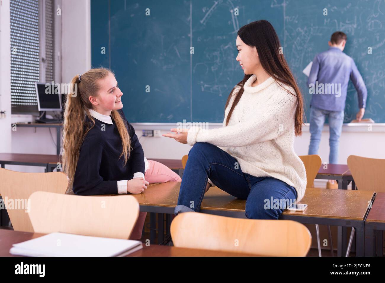 Student girls communicating in classroom Stock Photo - Alamy