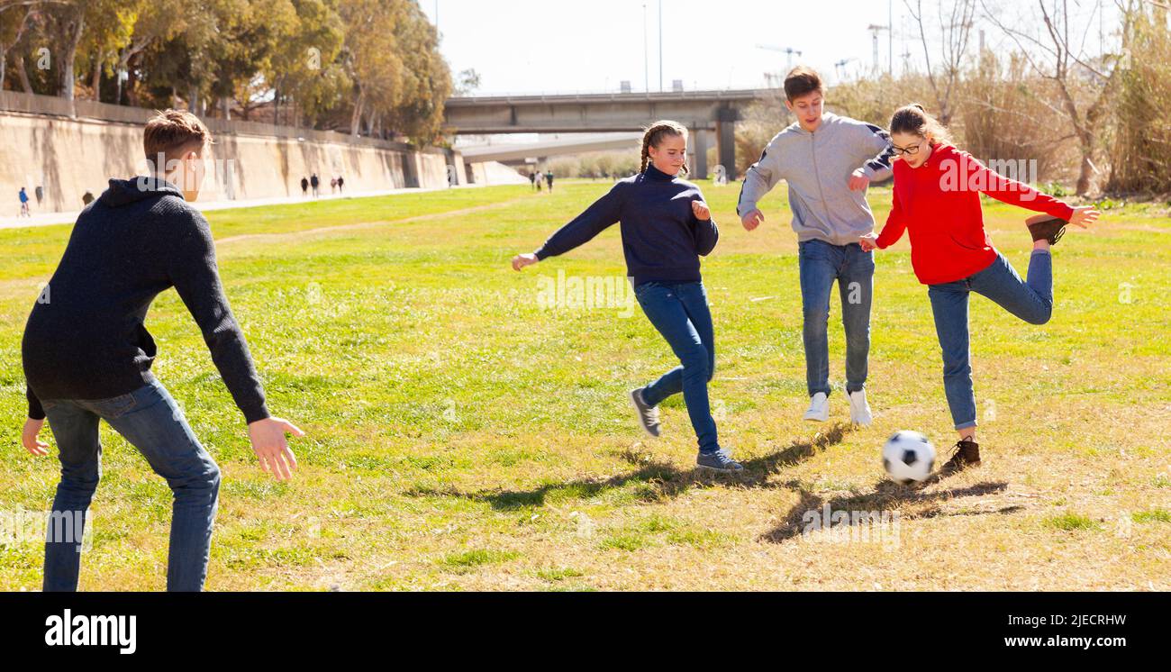 Teenagers play football with excitement Stock Photo - Alamy