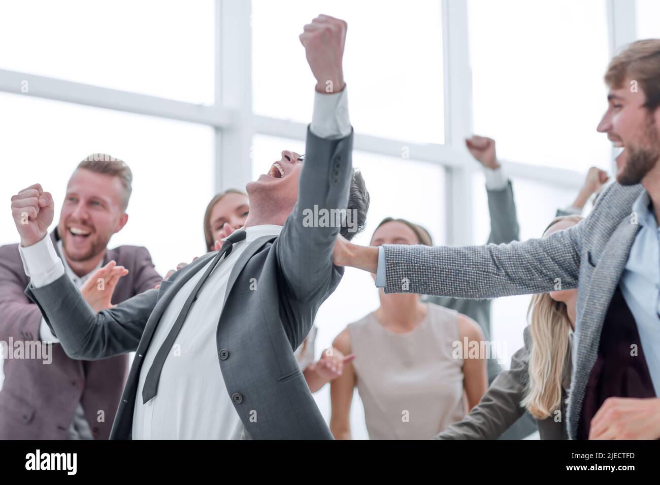 group of cheerful company employees congratulating their colleague ...