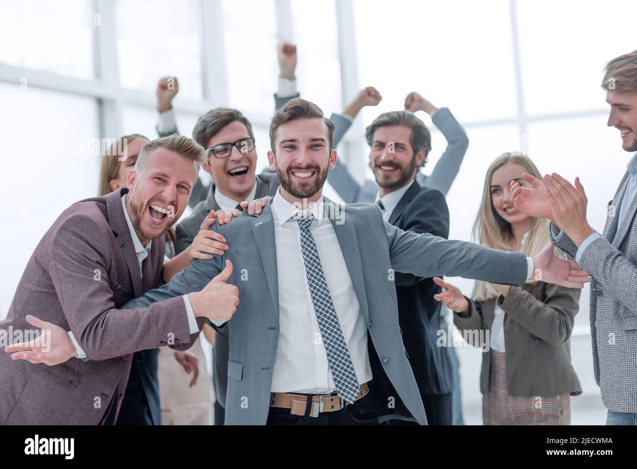 close up. happy business team hugging their leader Stock Photo - Alamy