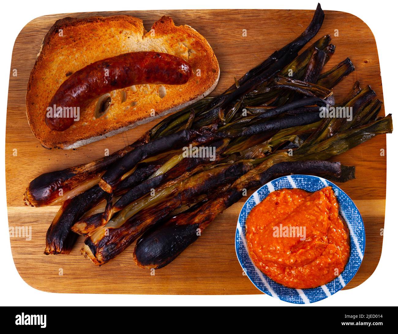 Calcot with romesco sauce and grilled botifarra Stock Photo - Alamy