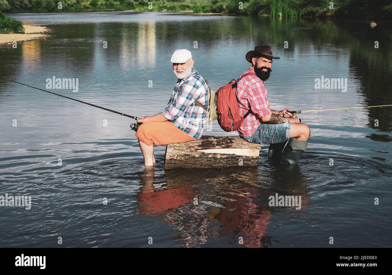 Fly rod and reel with a brown trout from a stream. Happy father and son ...