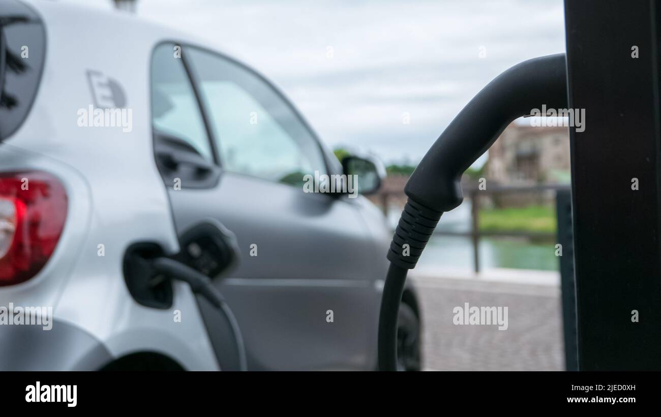 Smart electric car connected to the power plug for charging Stock Photo ...