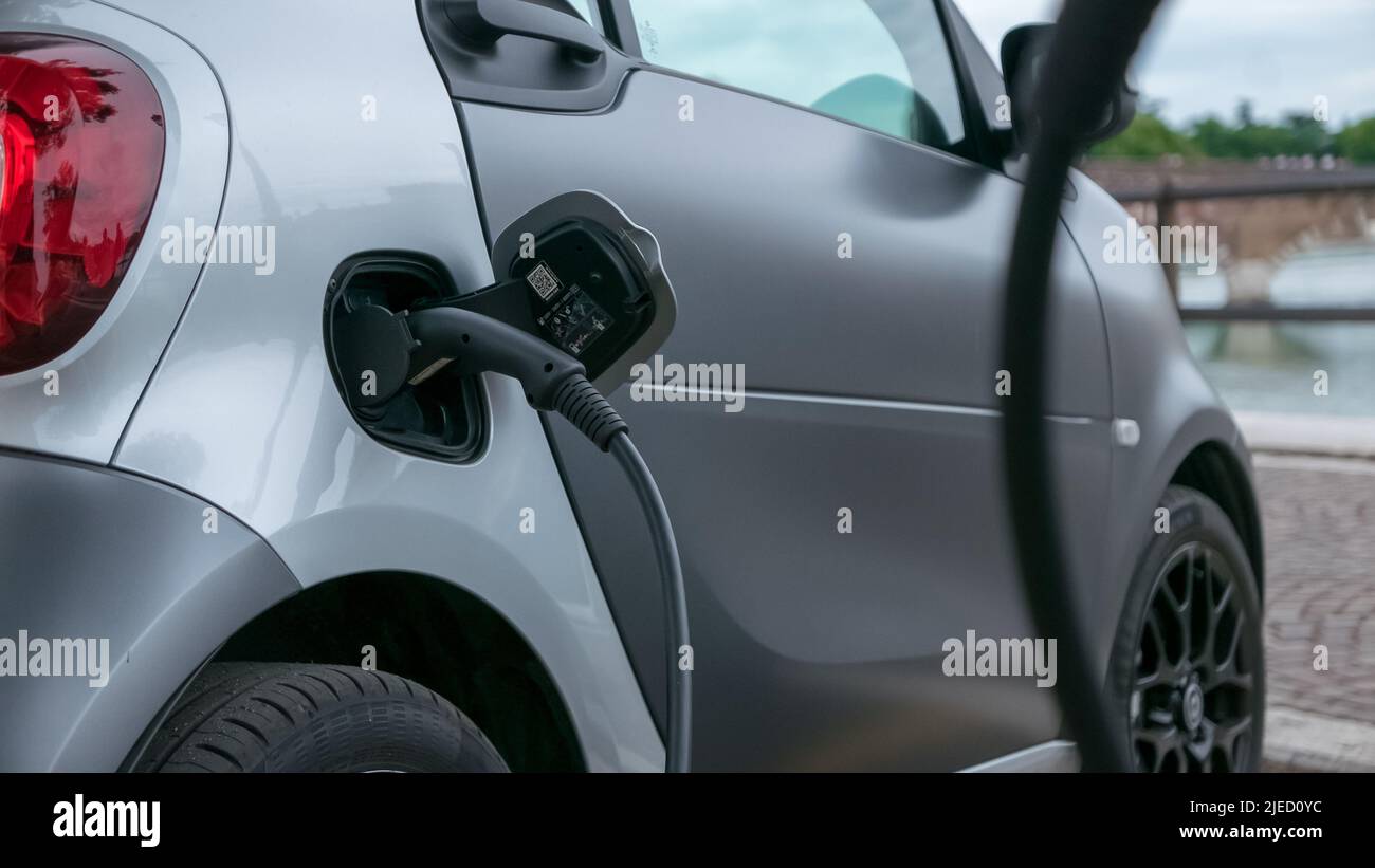 Smart electric car connected to the power plug for charging Stock Photo ...