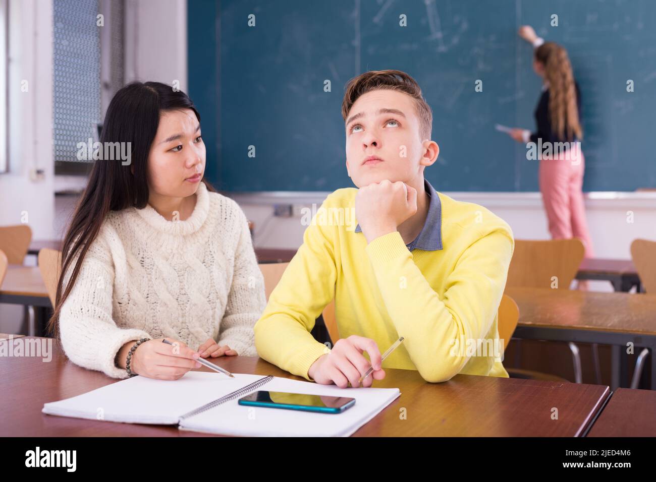 Young guy and chinese girl students doing lesson in classroom Stock ...
