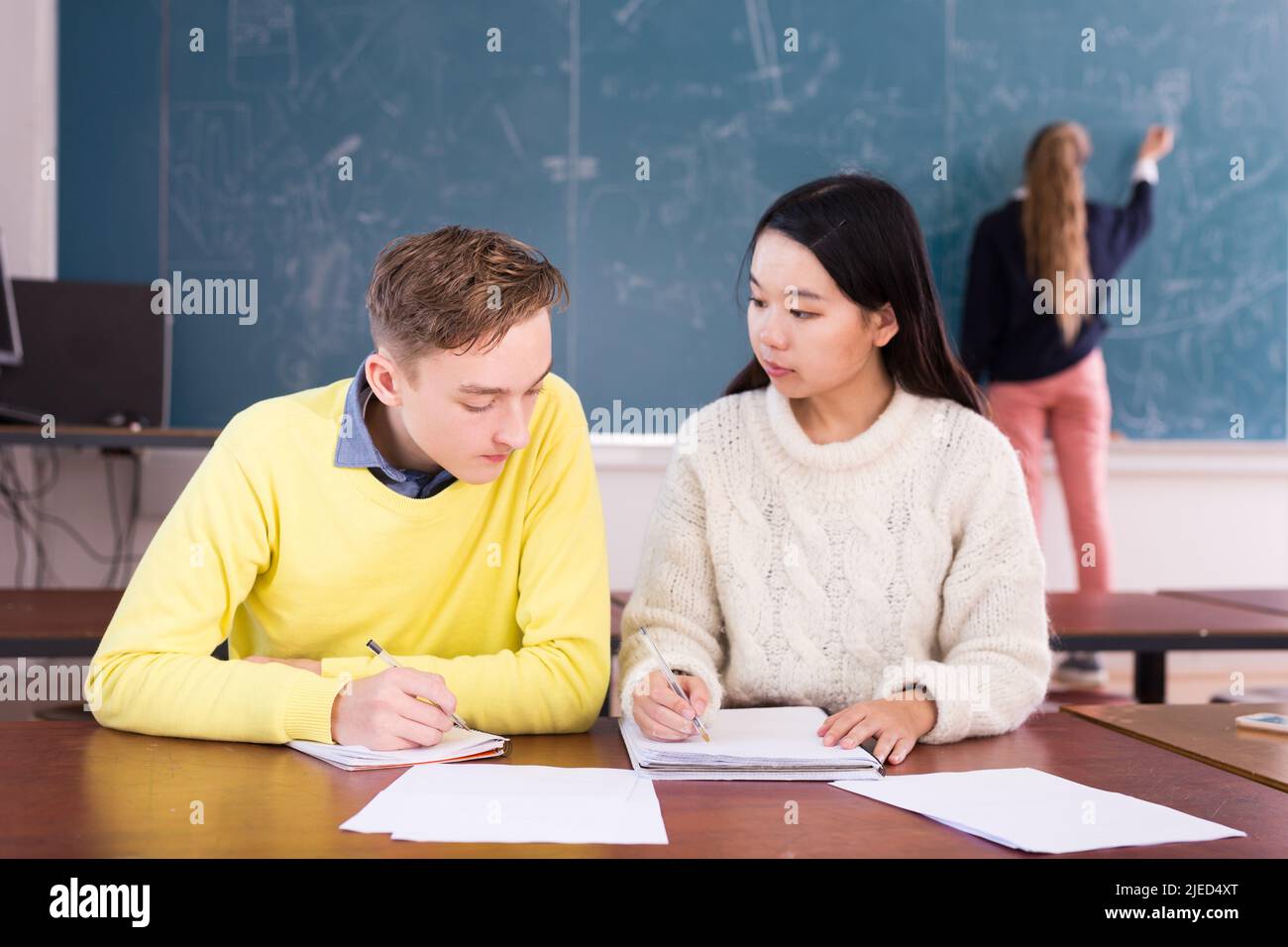 Two students studying together in schoolroom Stock Photo - Alamy
