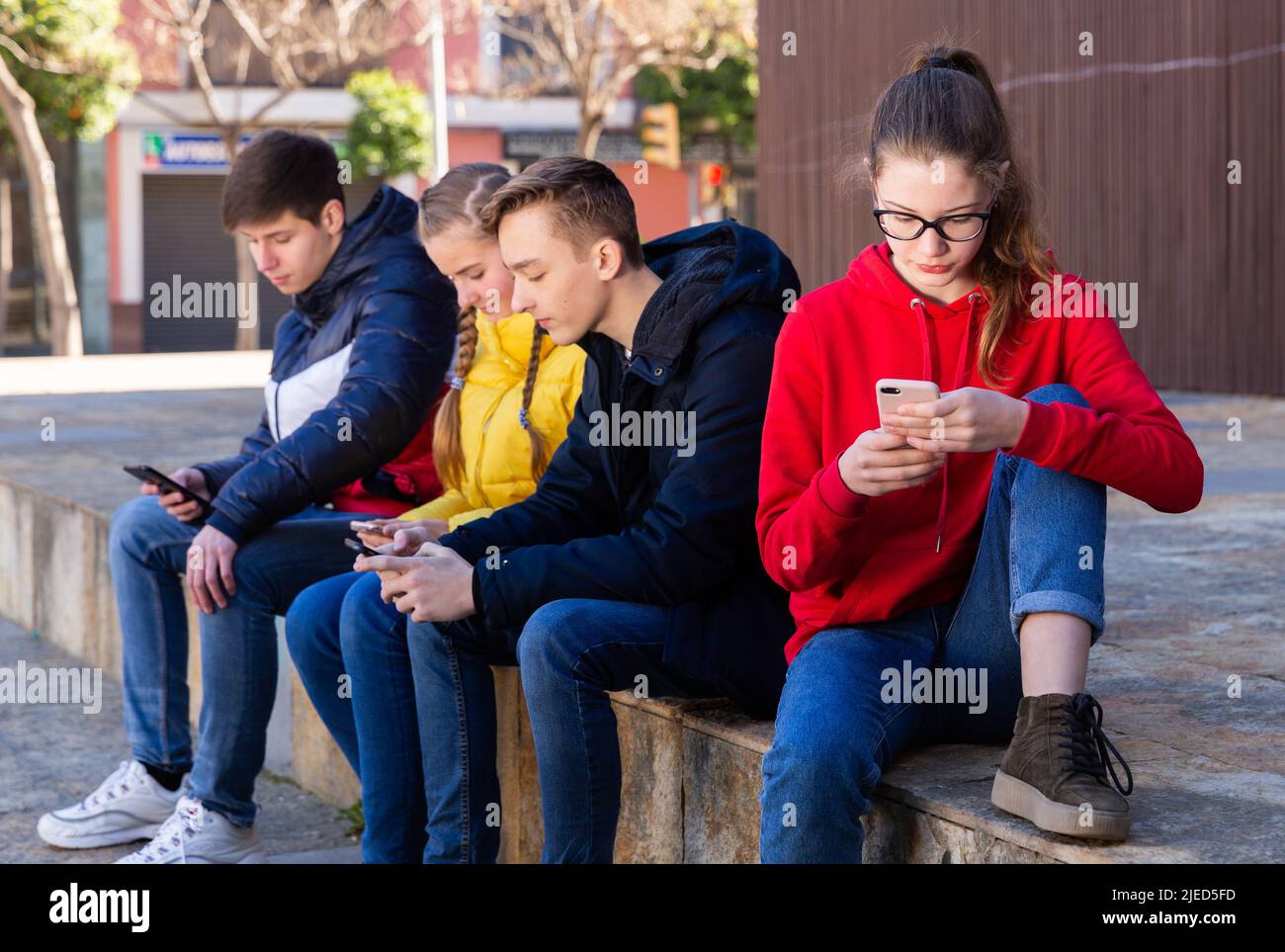 Teens using smartphones outdoors hi-res stock photography and images ...