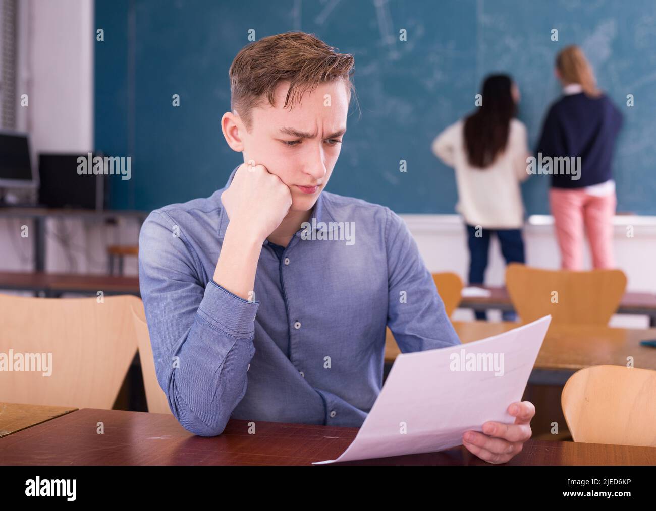 Young thoughtful guy preparing for the exam in classroom Stock Photo ...