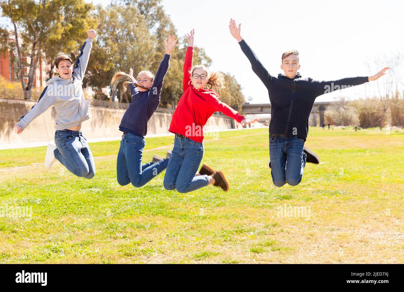 Happy teenagers jumping on the green lawn Stock Photo - Alamy