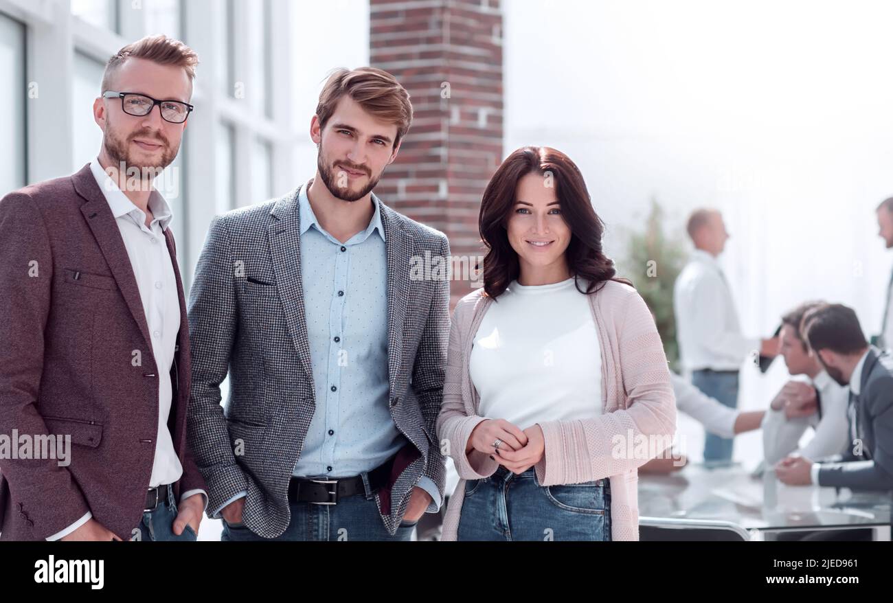 three young employees standing in a modern office Stock Photo - Alamy