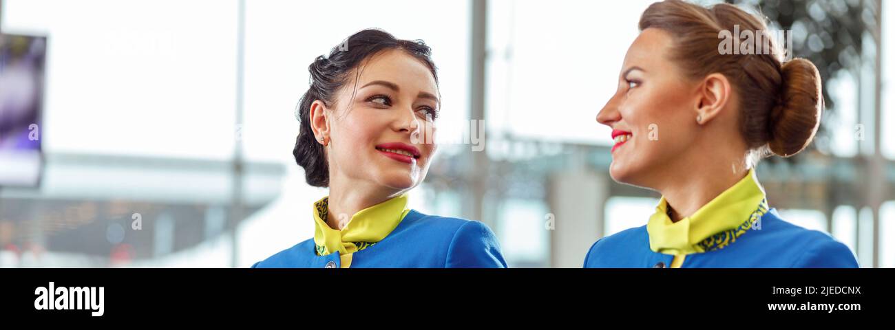 Two flight attendants walking arm in arm at airport terminal Stock ...