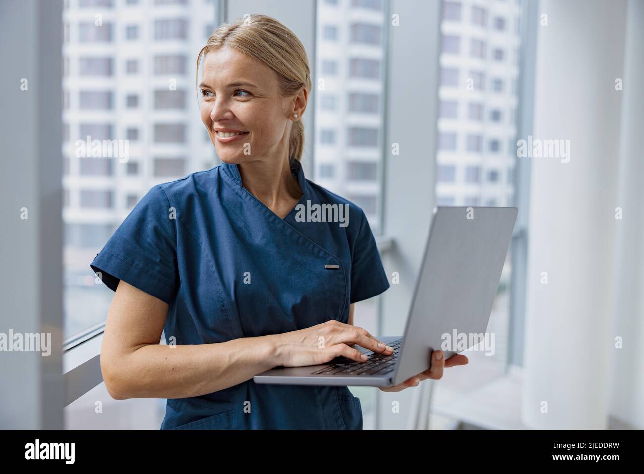 Female healthcare worker using laptop while working at doctor's office ...