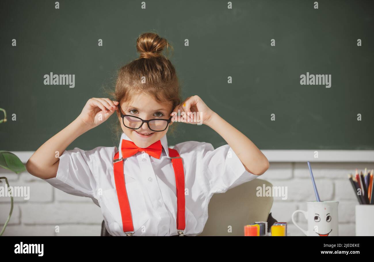 Cute child at school. Kid is learning in class on background of ...