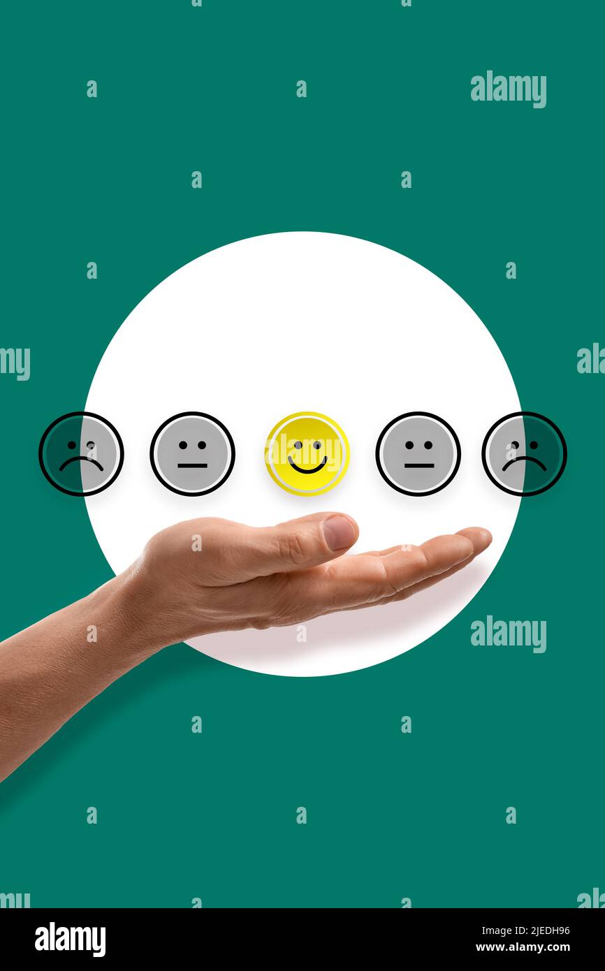 Male hand and different emoticons on green background. Satisfaction ...