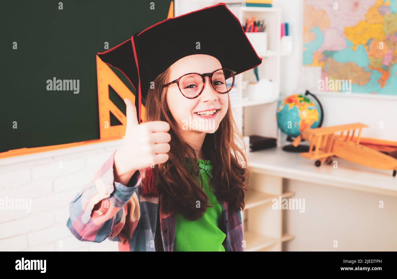 Funny pupil at the desk. Little girl from primary school. Portrait of ...