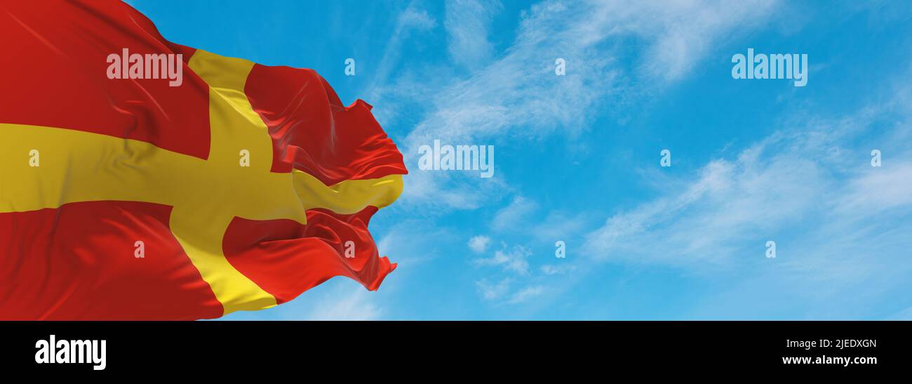 official flag of Skanska , Sweden at cloudy sky background on sunset ...