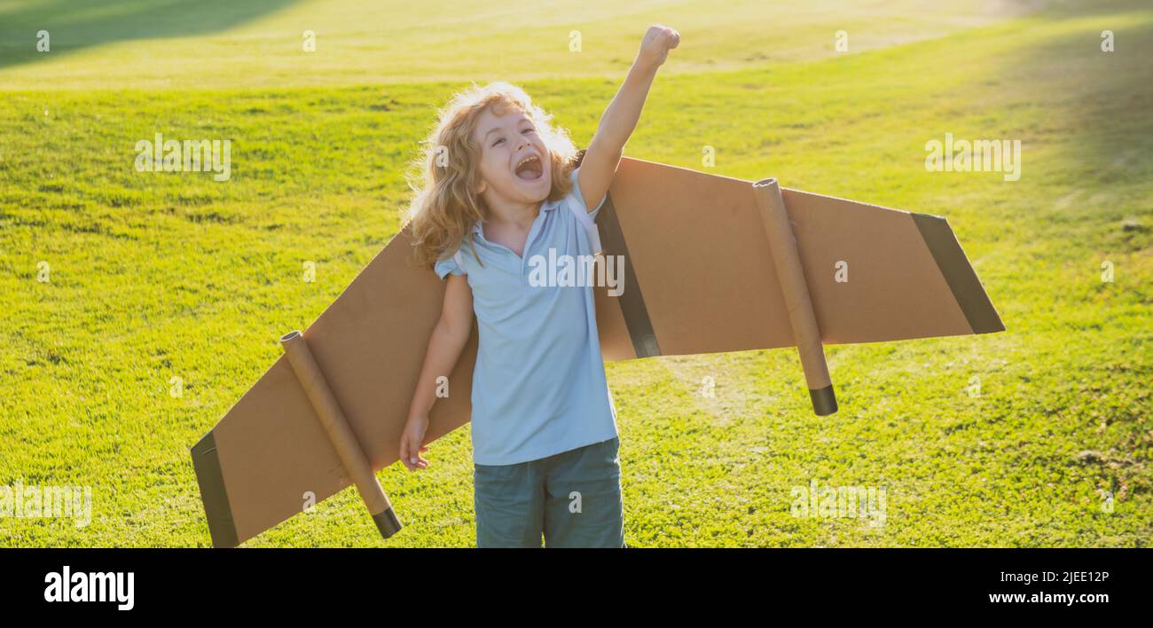 Child playing with toy plane wings in summer park. Innovation ...