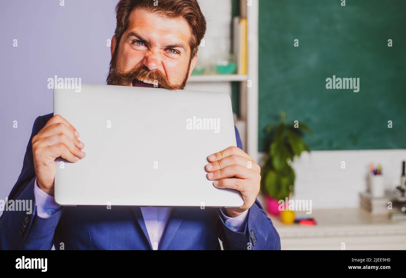 Funny teacher with laptop notebook in classroom at school. Excited ...