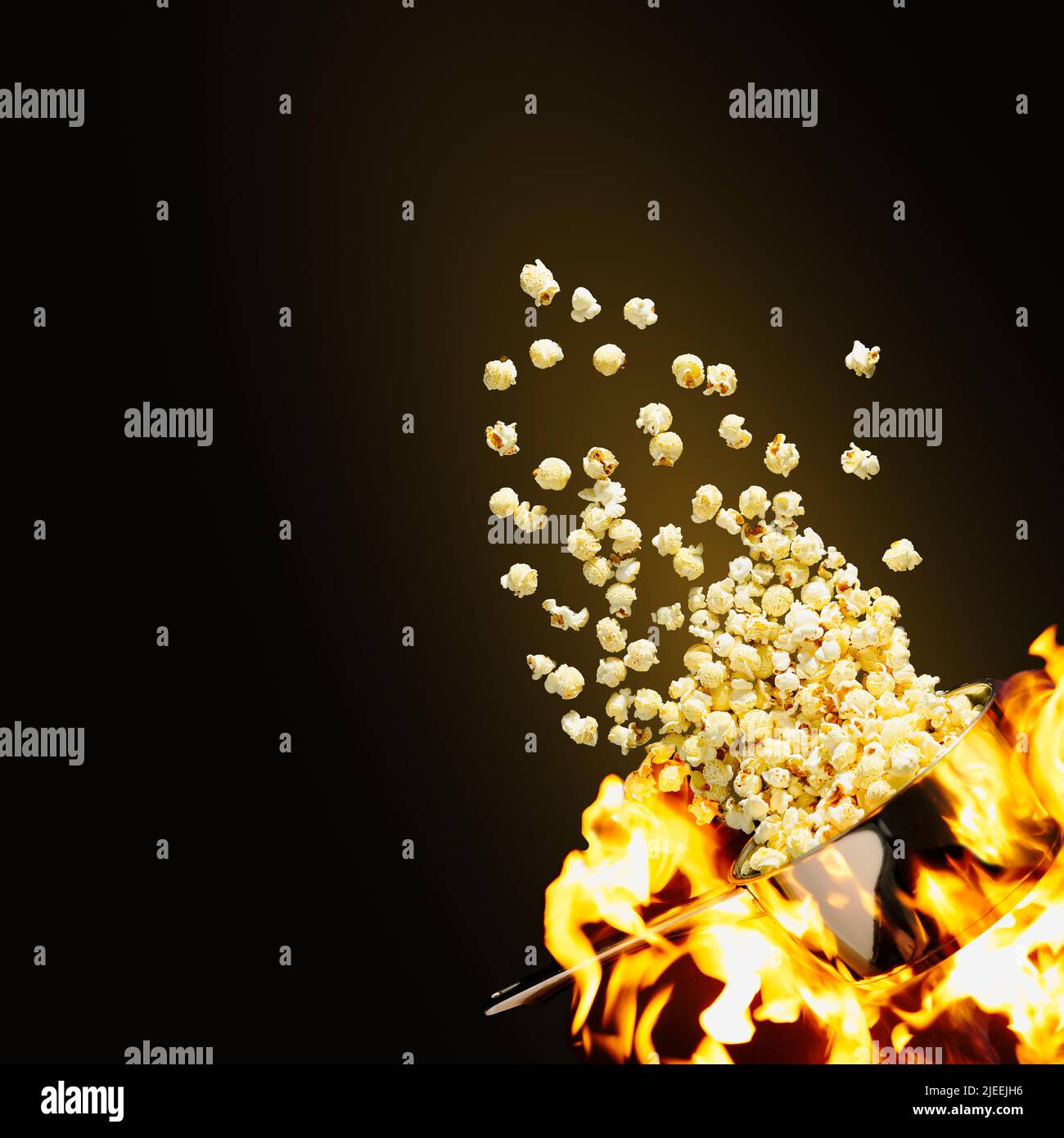Flying popcorn on a dark background. Hot popcorn flying from pot under ...