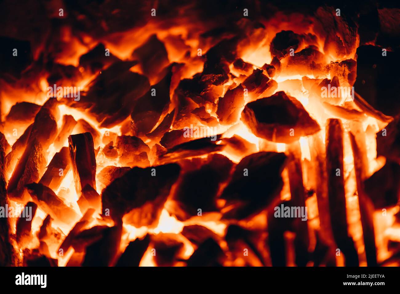 Abstract background of glowing coals in fireplace with fire flames ...