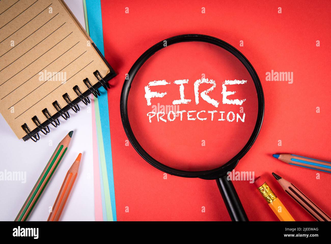 Fire Protection. Magnifying glass, notebook and stationery on white and ...