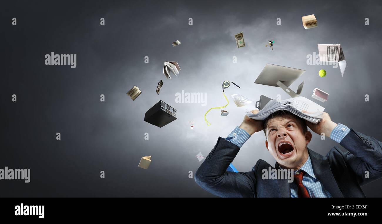 Young stressed man ripping documents with frustrated facial expression ...