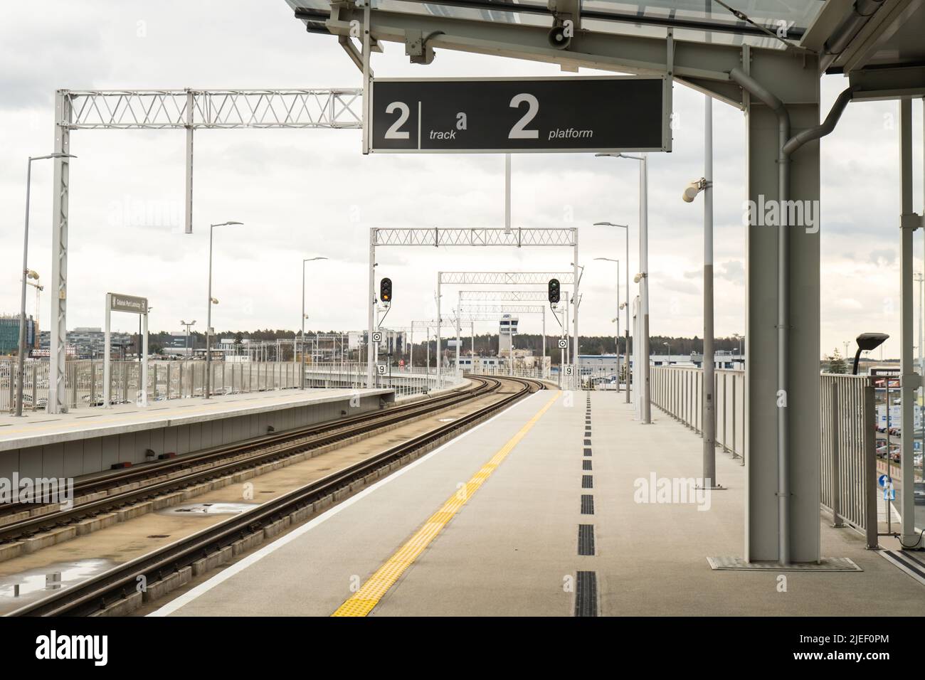 Walk way in train station with no people. Empty Passanger train railway station platform. Sign ...