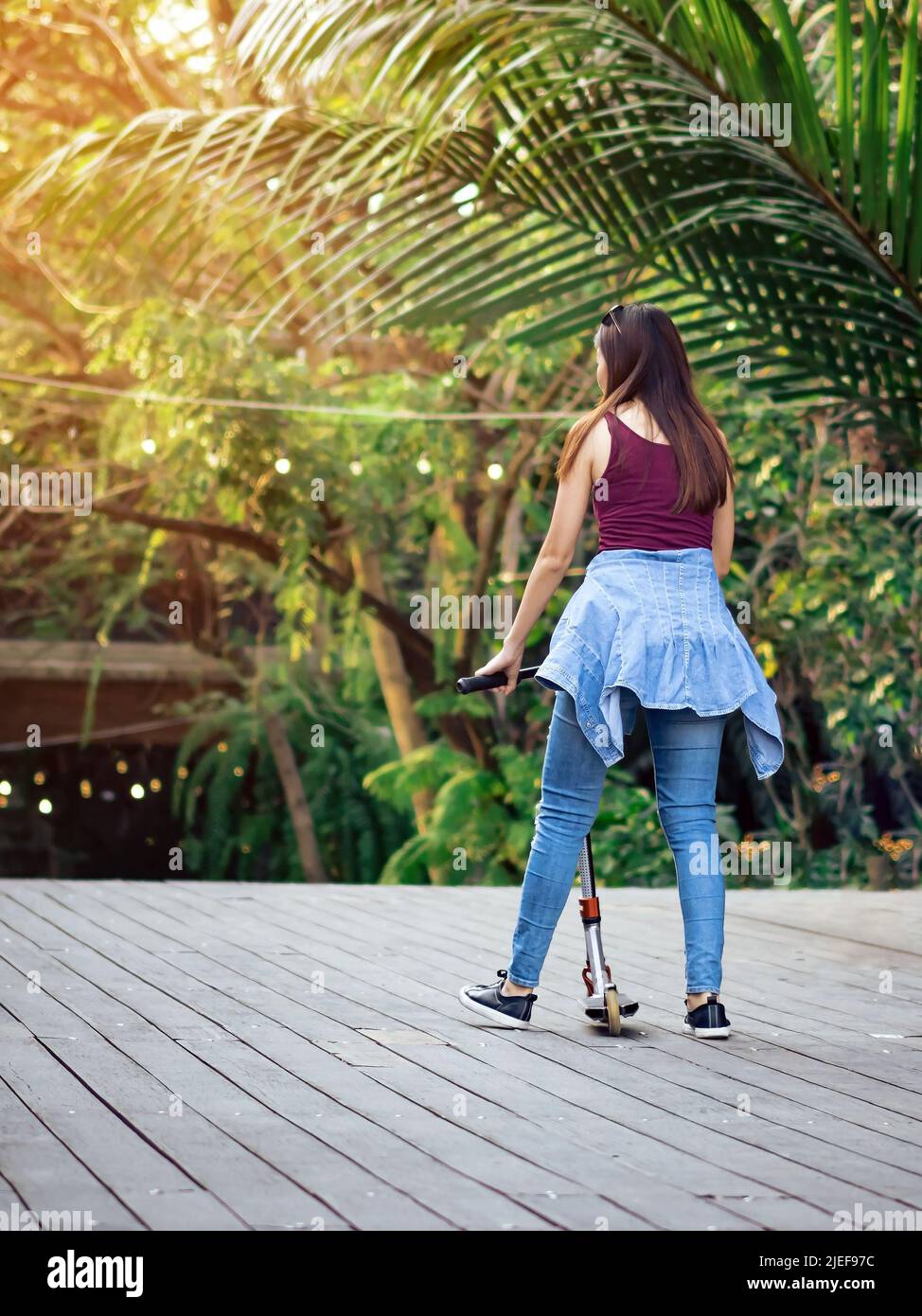 Asian woman enjoy playing and riding modern extreme stunt kick scooter ...