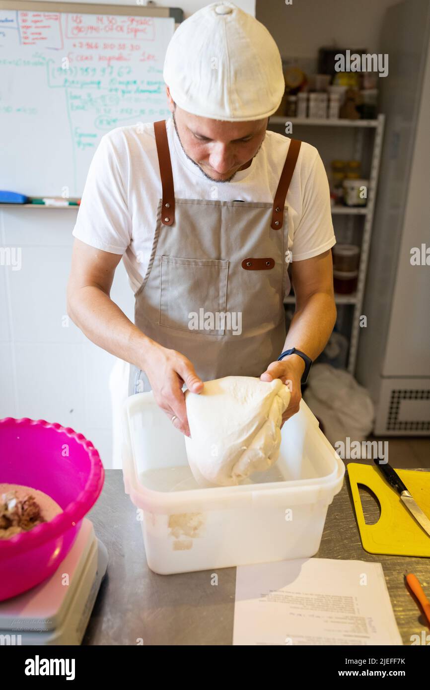 The process of making wheat bread in an artisan bakery. The folding of ...